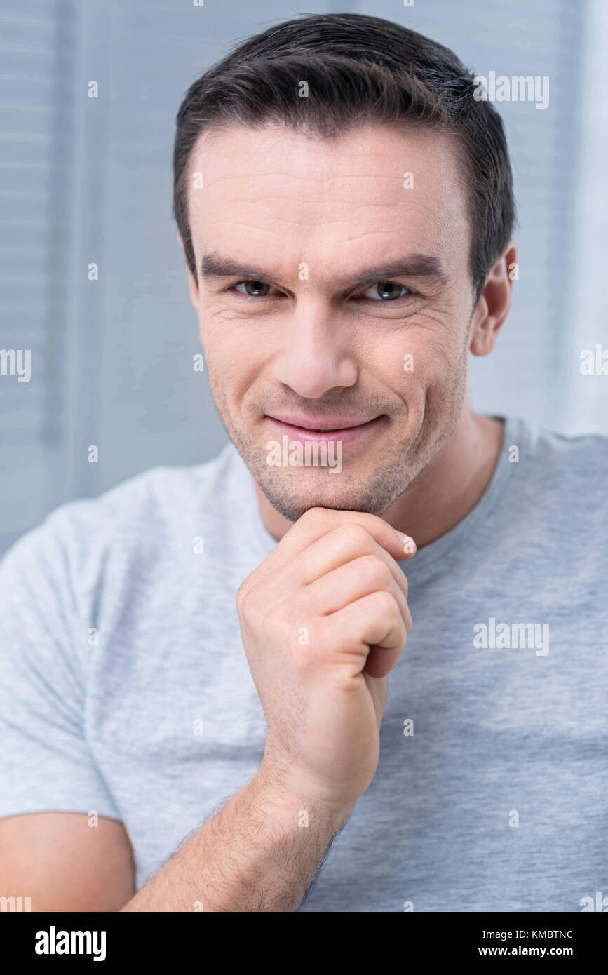 Cunning pleasant man coming up with joke Stock Photo - Alamy