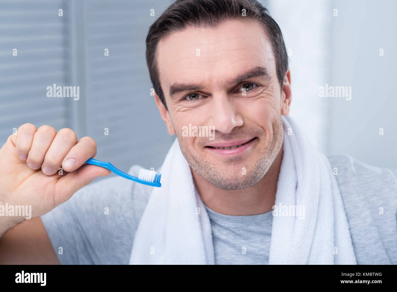 Joyful attractive man taking care of his teeth Stock Photo - Alamy