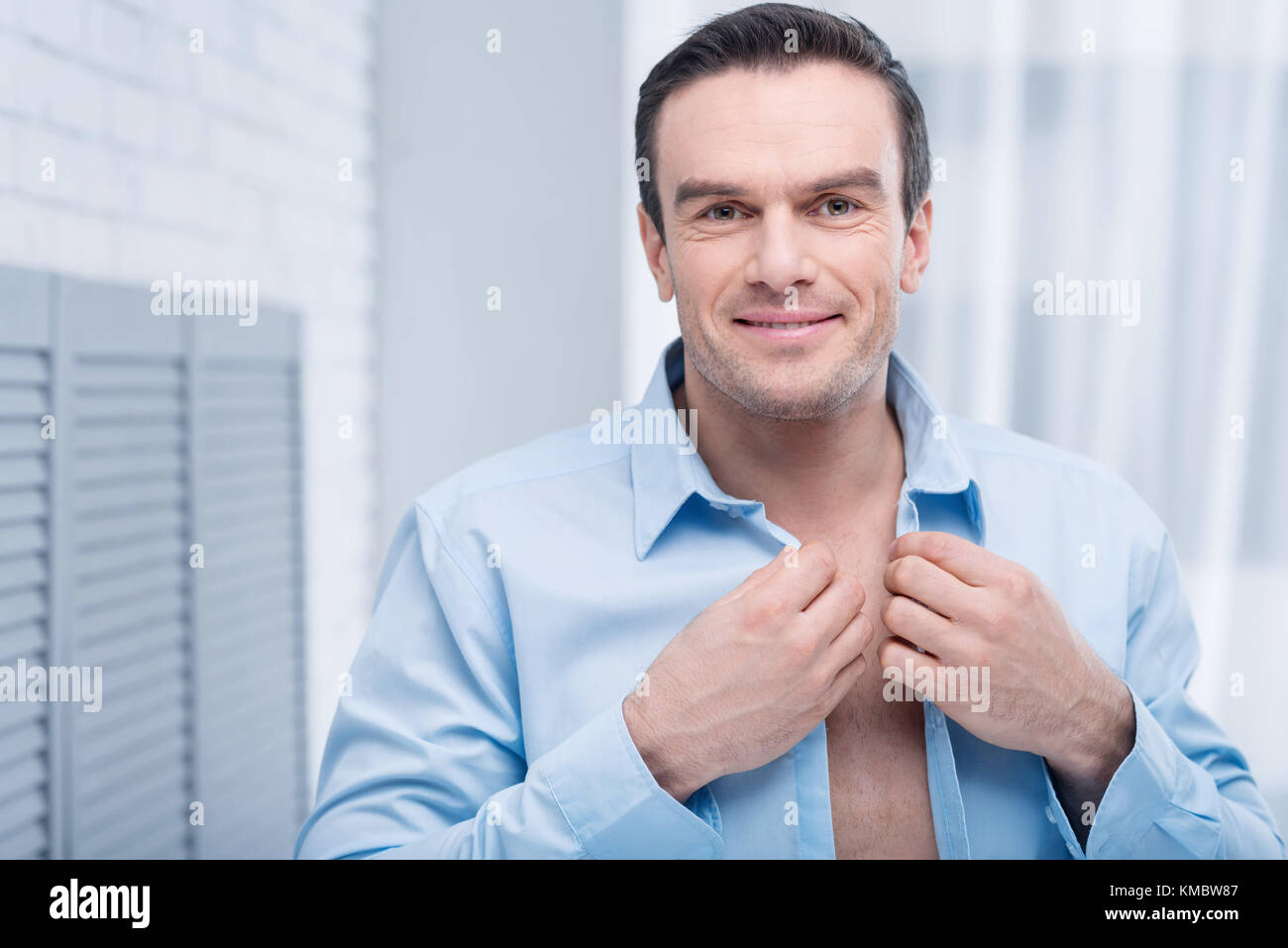Happy glad man dressing for work Stock Photo - Alamy