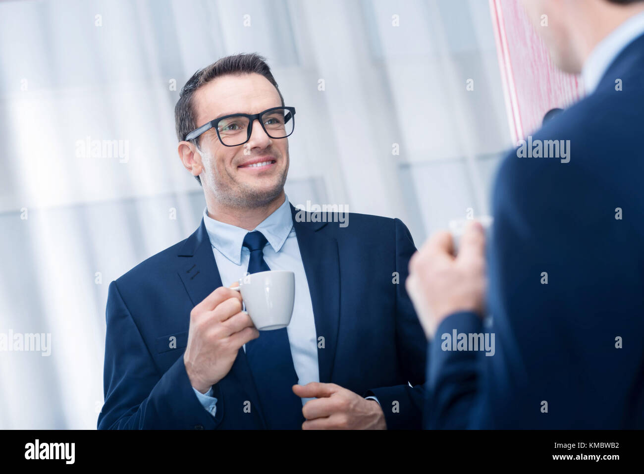Joyful nice man sipping coffee Stock Photo - Alamy