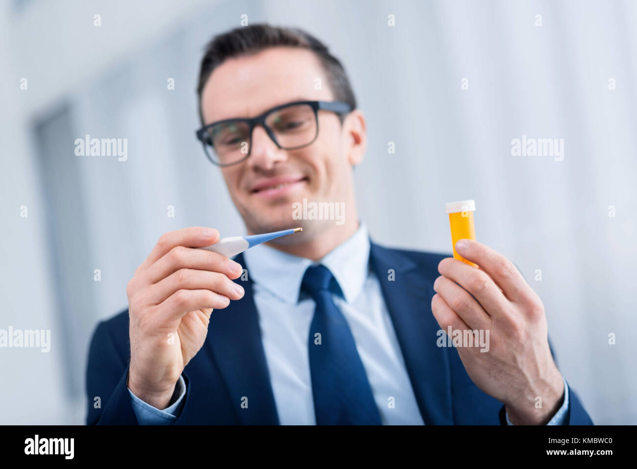 Strong positive man checking his temperature Stock Photo - Alamy
