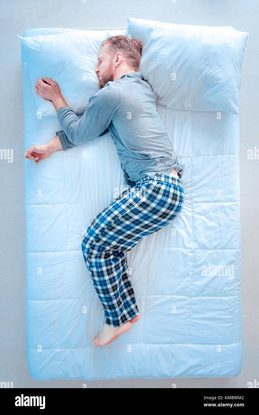 Tired man lying in embryo pose Stock Photo - Alamy