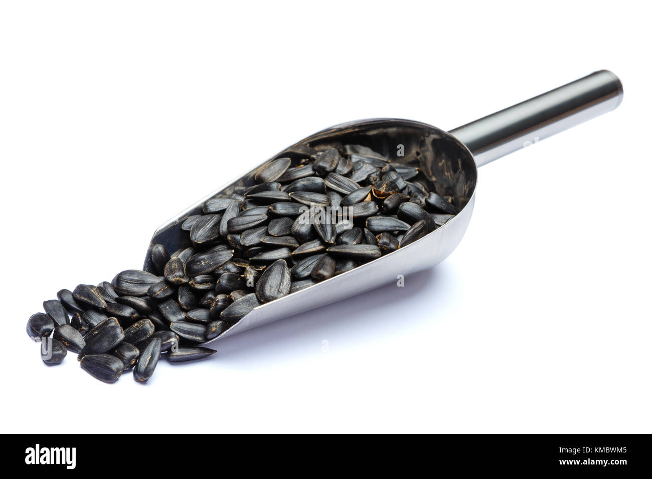 Scoop of sunflower seeds isolated on a white. Clipping path Stock Photo ...