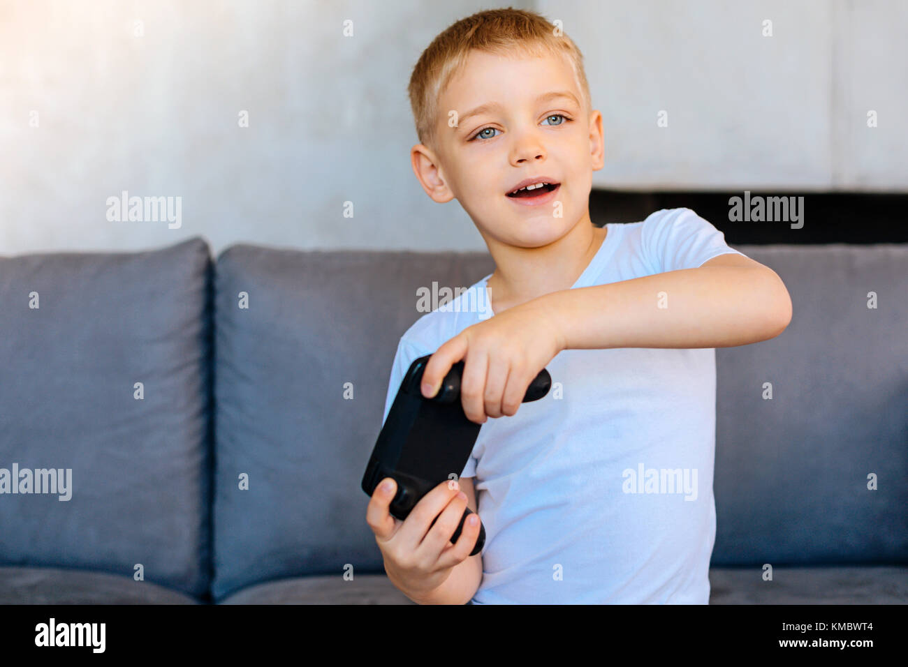 Positive young boy playing video games Stock Photo - Alamy