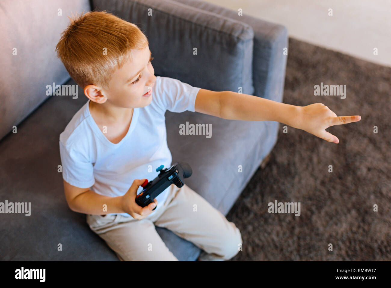 Pleasant blonde boy pointing at the screen Stock Photo - Alamy