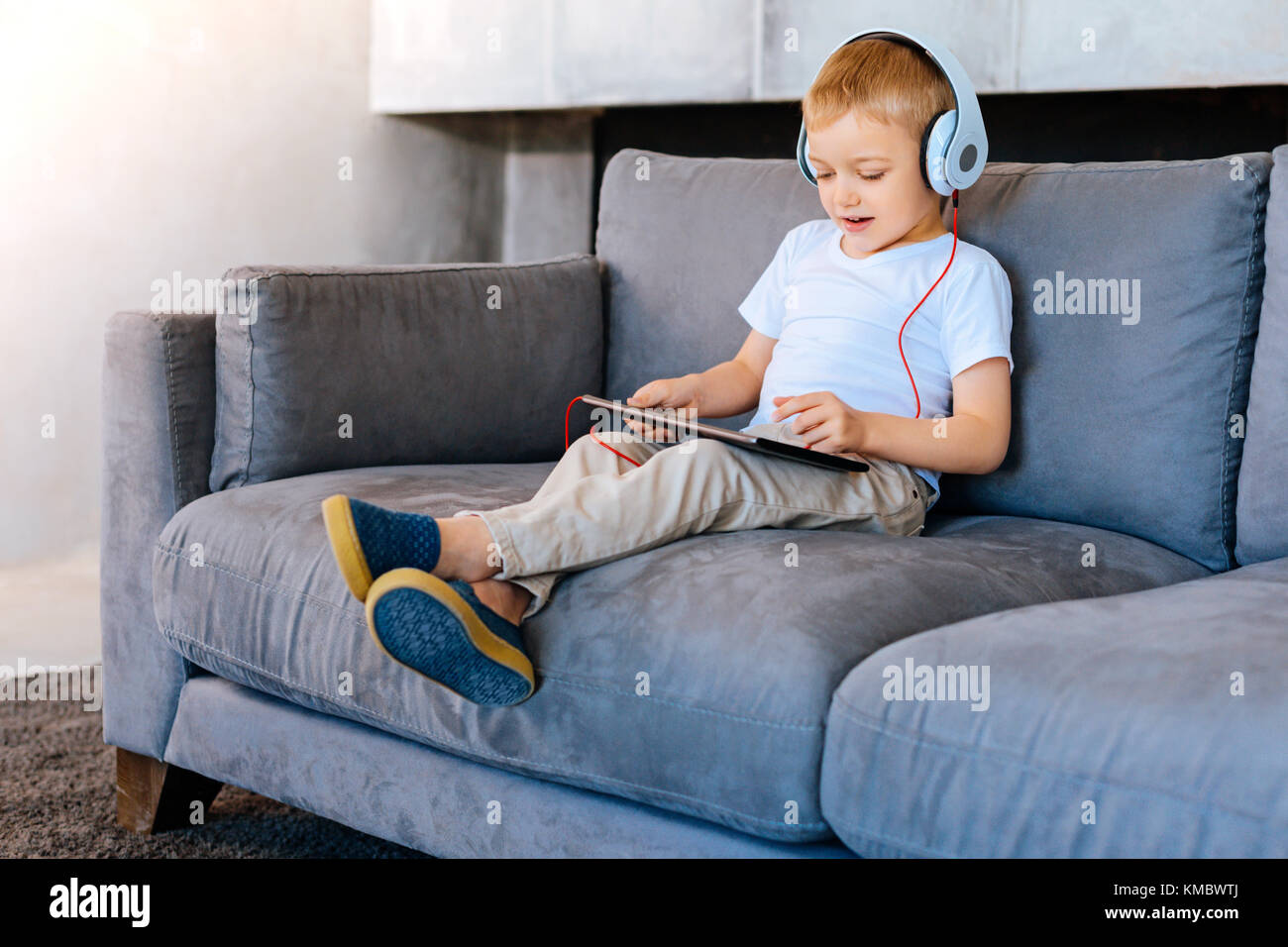 Delighted nice boy wearing headphones Stock Photo - Alamy