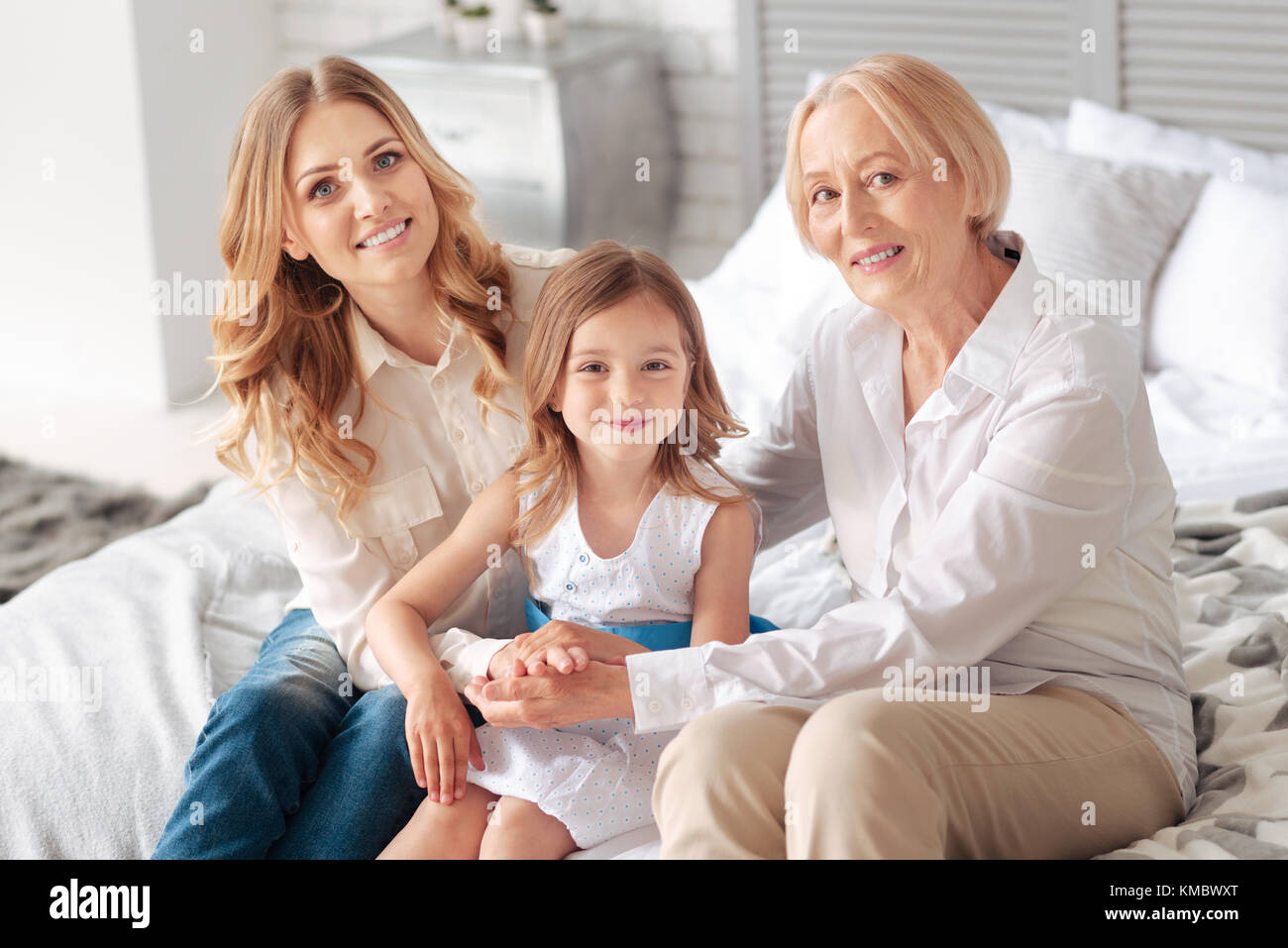 Positive cheerful family sitting together Stock Photo - Alamy