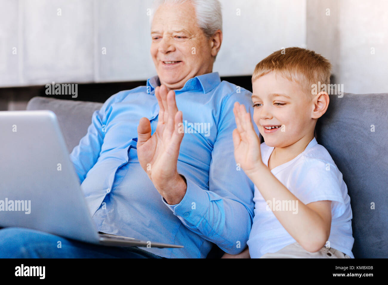 Joyful nice boy and grandfather waving their hands Stock Photo - Alamy
