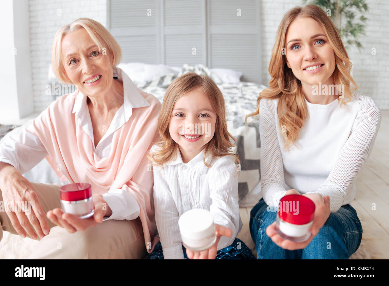 Joyful happy family showing you bottles of cream Stock Photo - Alamy