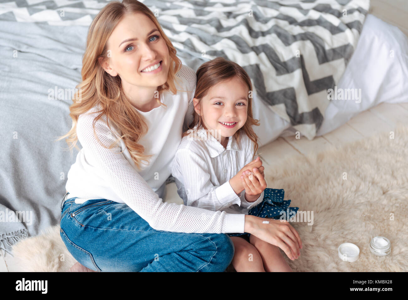 Joyful positive mother and daughter sitting together Stock Photo - Alamy