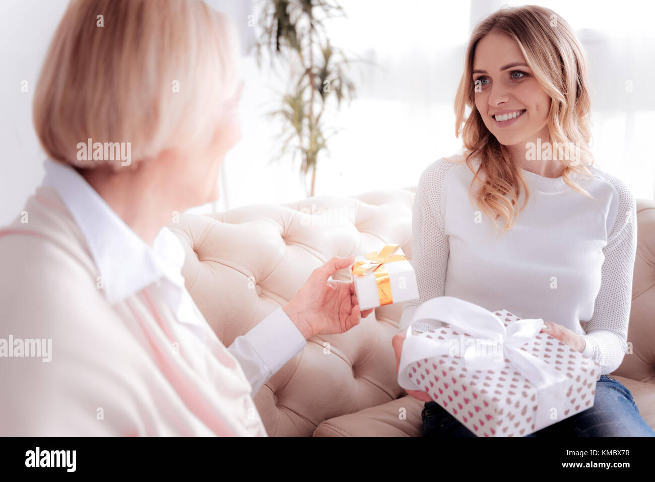 Delighted cheerful women exchanging gifts Stock Photo - Alamy