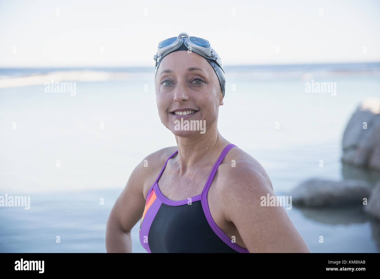 Portrait smiling confident female open water swimmer at ocean Stock ...