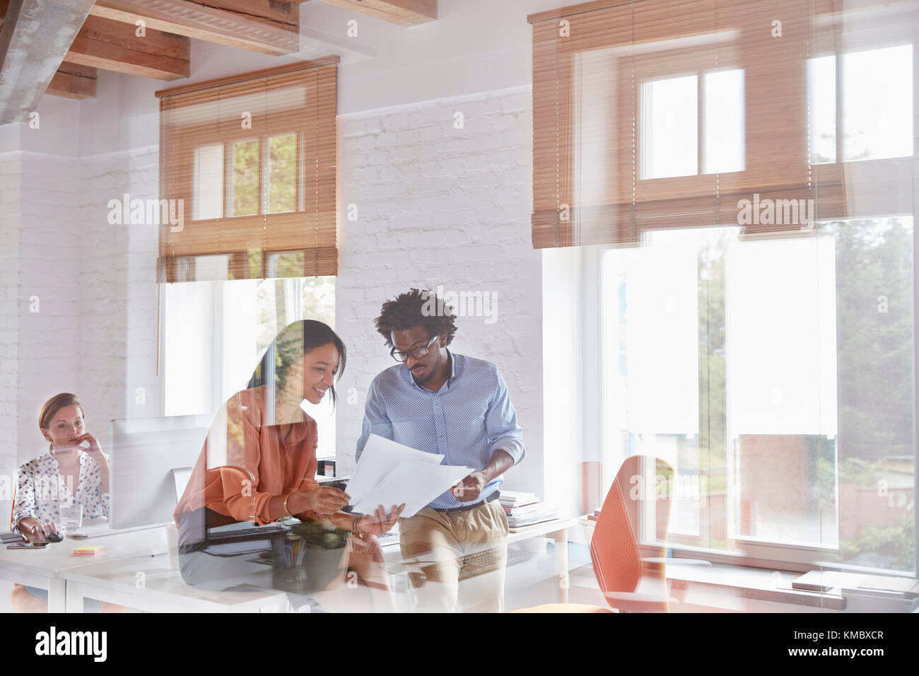 Business people discussing paperwork in office Stock Photo - Alamy
