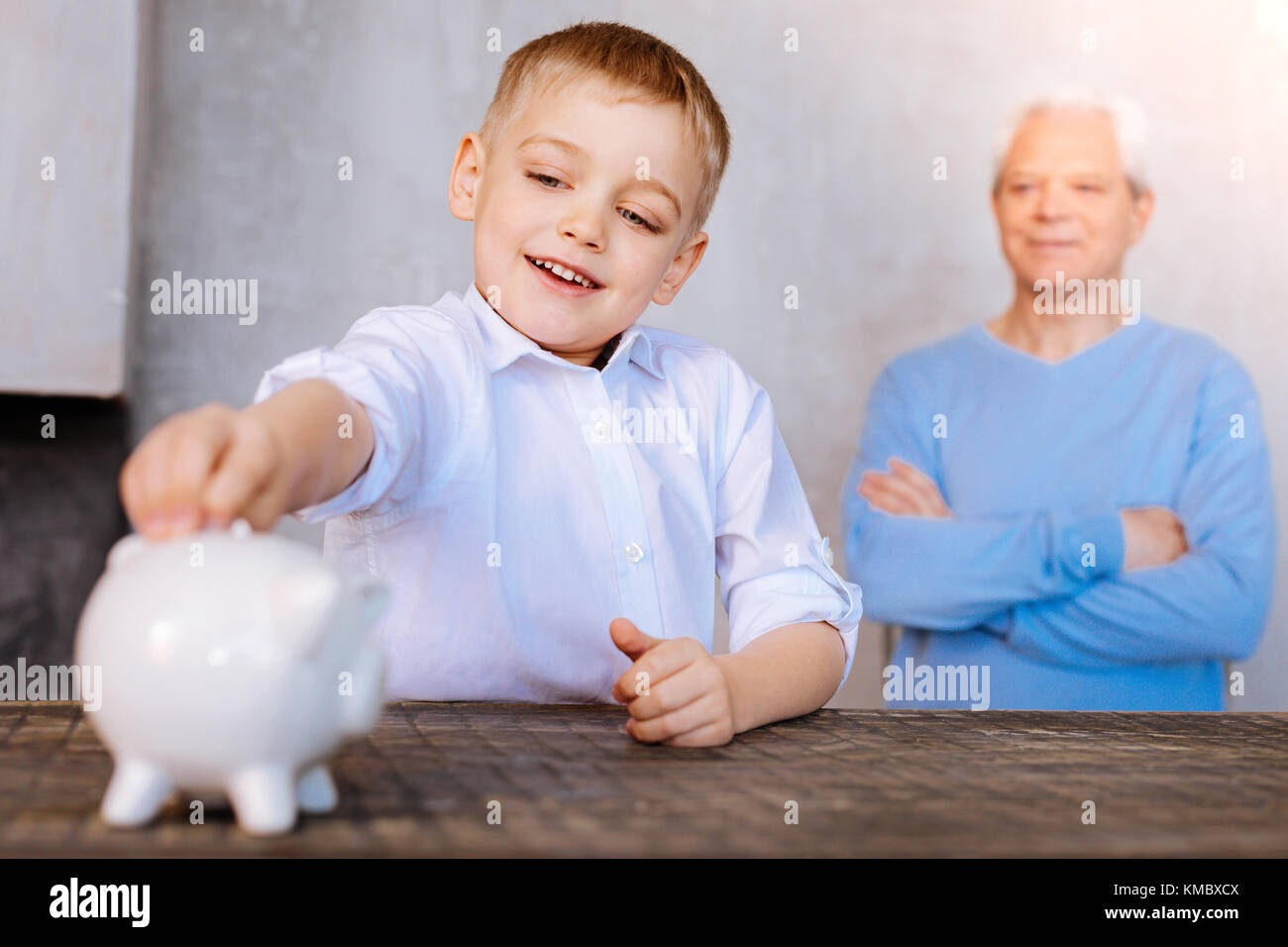 Positive cute boy saving money Stock Photo - Alamy