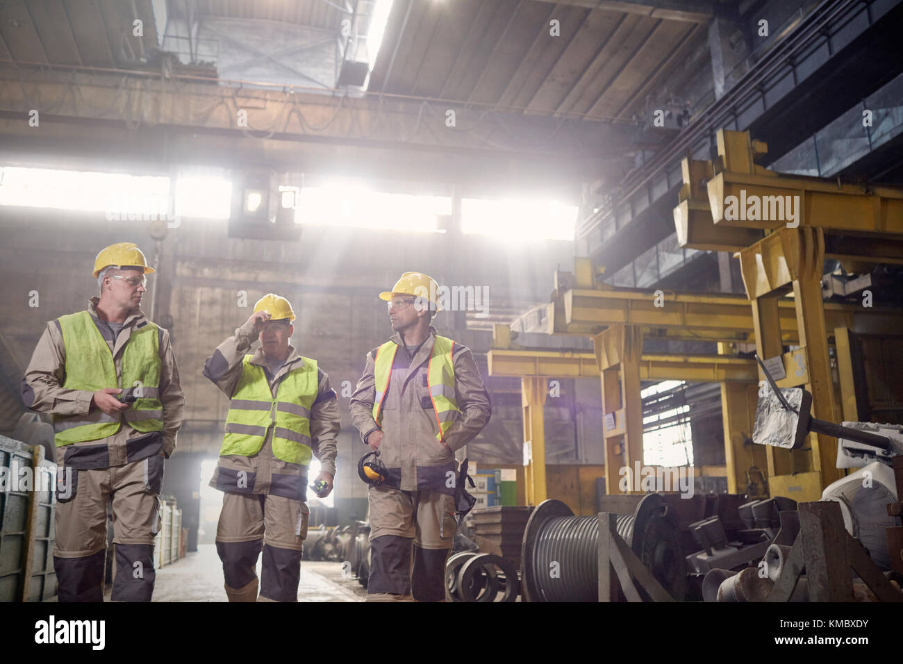 Steelworkers walking and talking in steel mill Stock Photo - Alamy