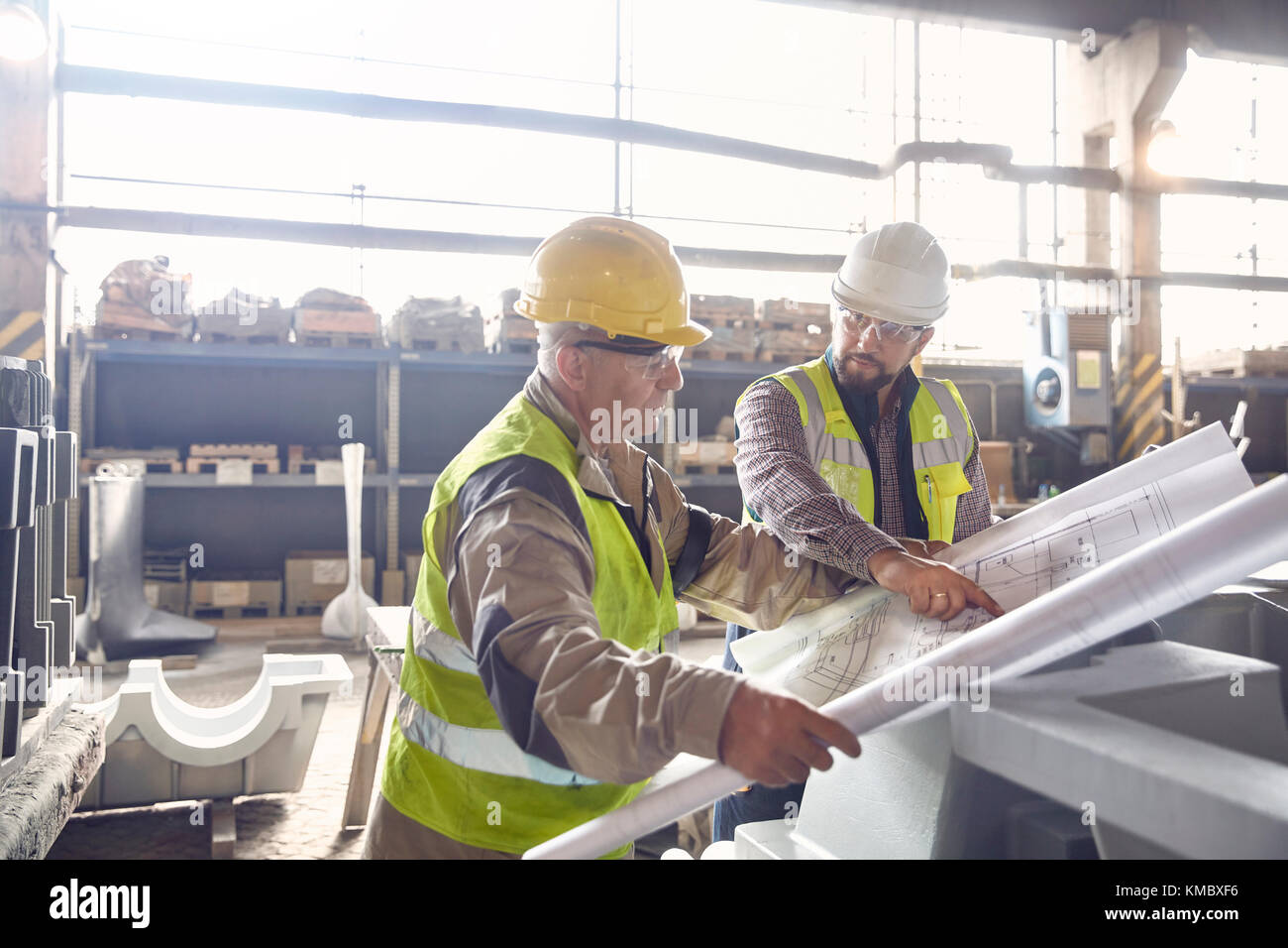 Steelworker and engineer reviewing blueprints in steel mill Stock Photo ...