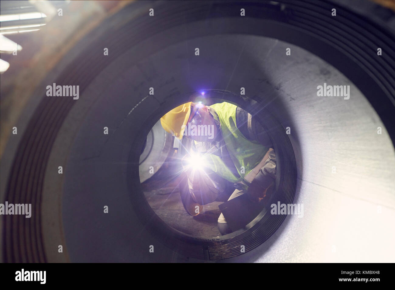 Steelworker with flashlight examining steel part in steel mill Stock ...