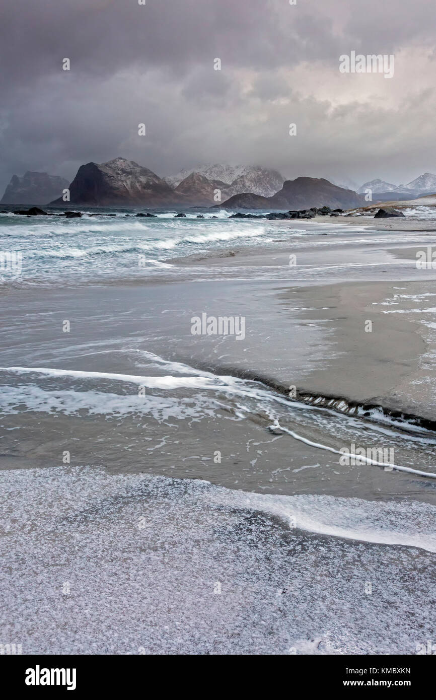Rugged mountains behind cold,ocean beach tide,Storsandnes,Lofoten ...