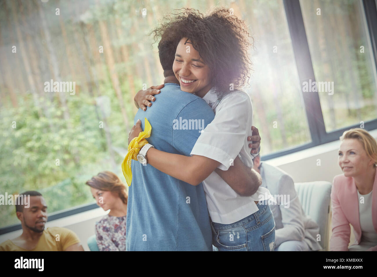 Smiling woman hugging man in group therapy session Stock Photo - Alamy