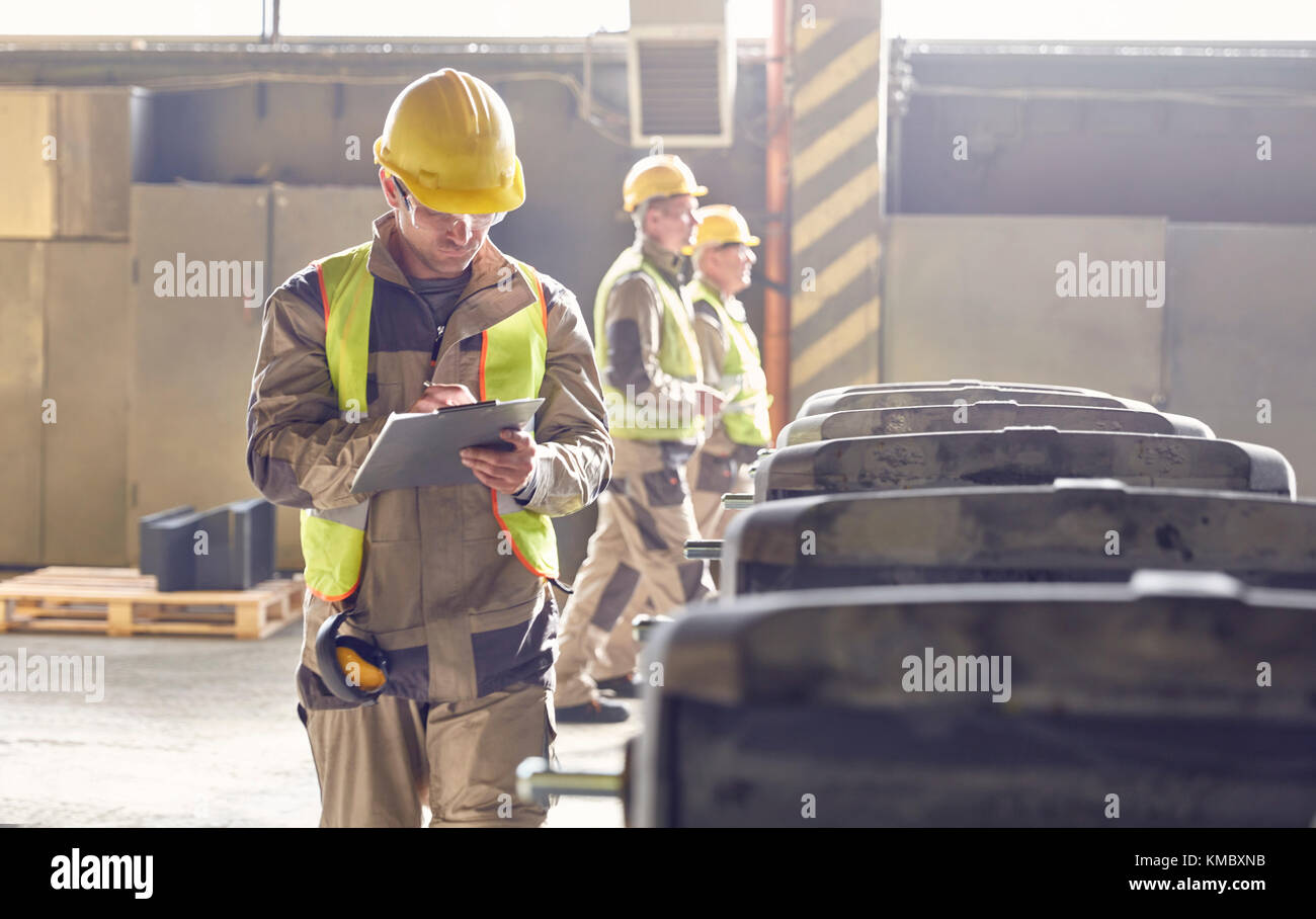 Steelworker writing on clipboard in steel mill Stock Photo - Alamy