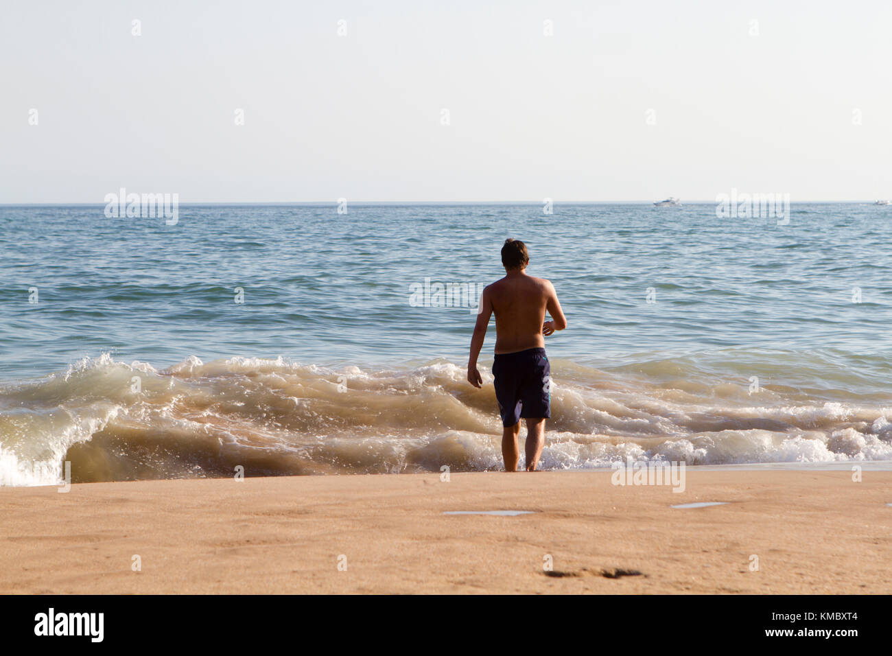 Young man enter in the sea Stock Photo - Alamy