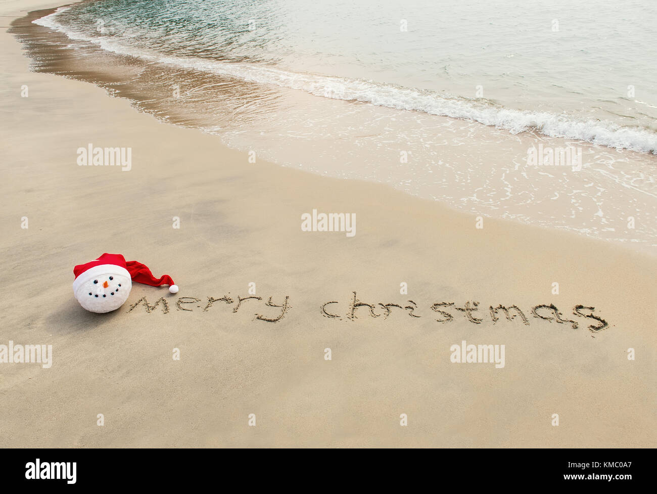Merry Christmas written on tropical beach white sand with xmas snowman ...