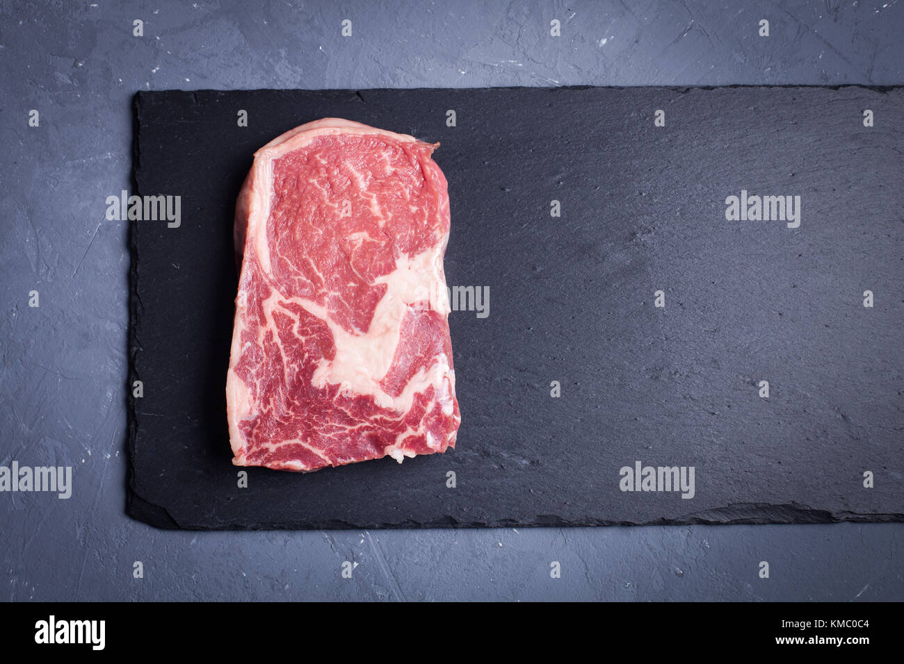 Raw marble, fresh piece of meat, black Angus ribeye steak on a dark ...