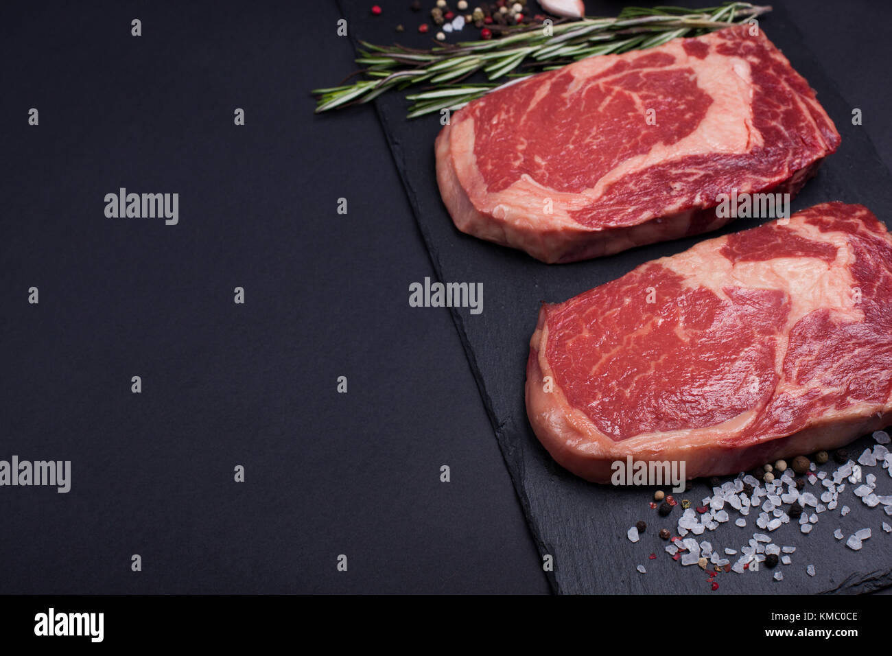 Two fresh raw marble meat, black Angus ribeye steak with spices on a ...