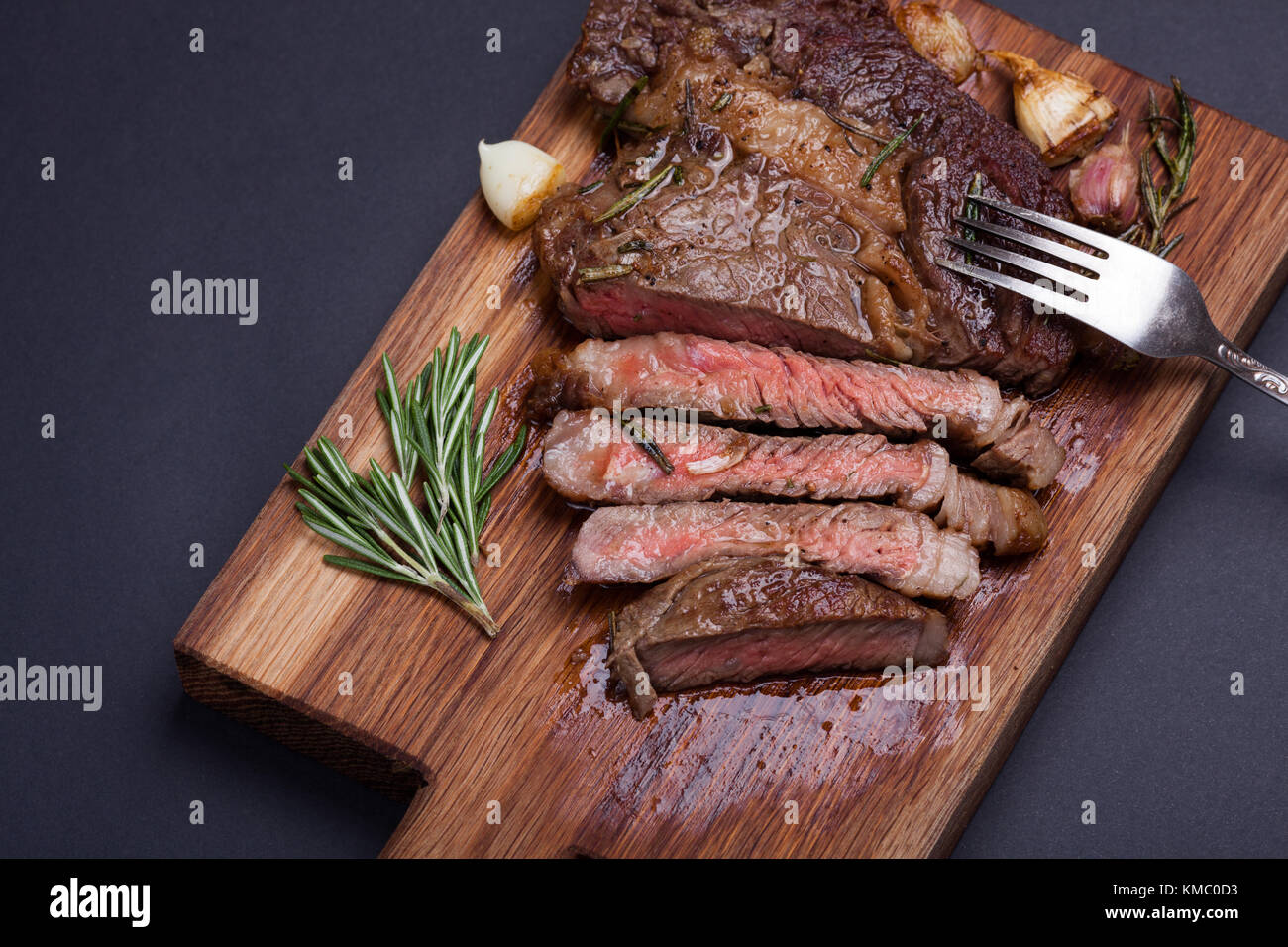 Grilled rib-eye steak of marble beef closeup with spices on a wooden ...