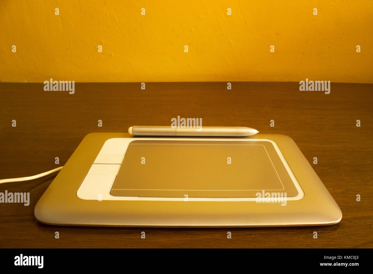 Horizontal photo of silver pen tablet on a brown wood table Stock Photo ...