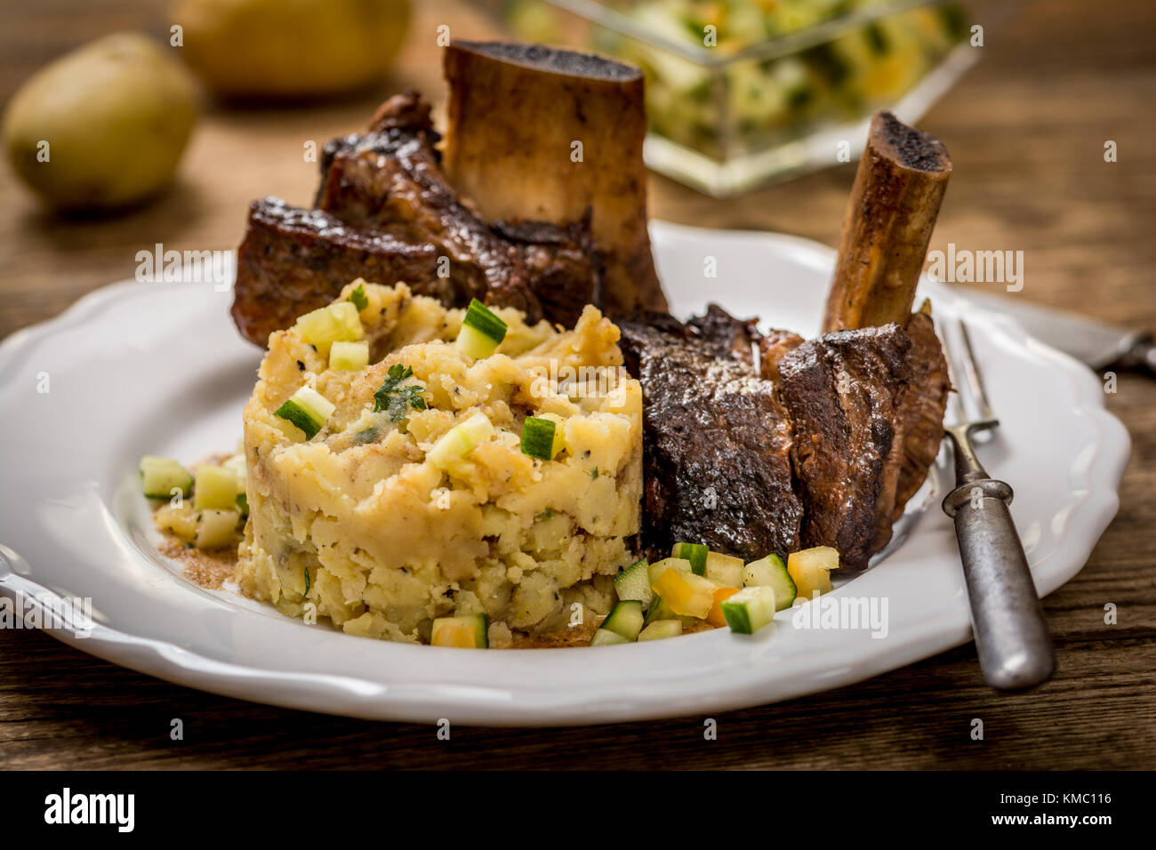 Grilled beef rib with mashed potatoes on wood table Stock Photo - Alamy