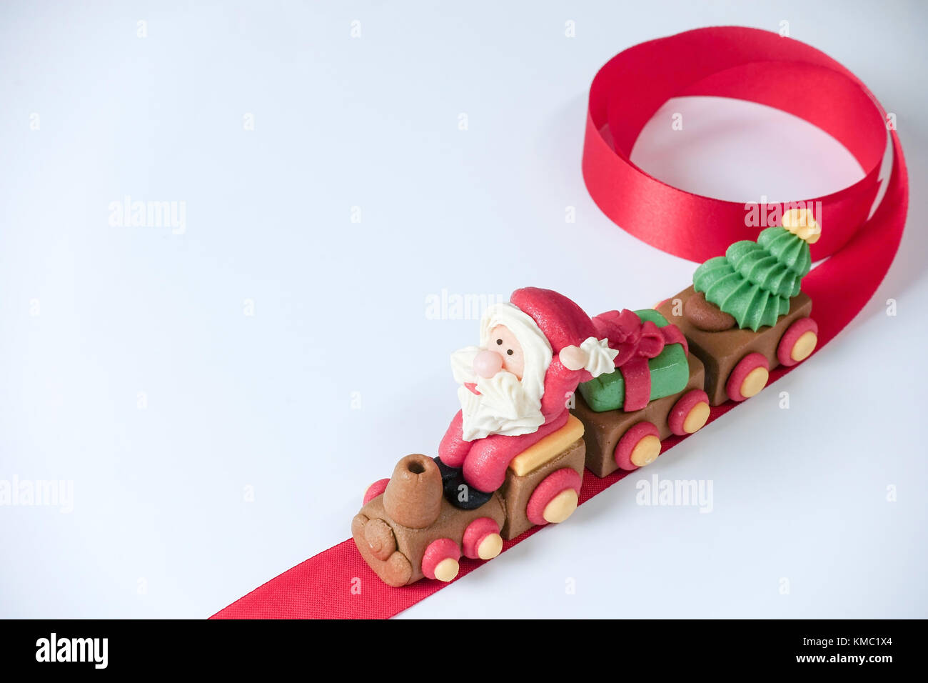 Santa claus driving train on red ribbon with pulling christmas trees ...