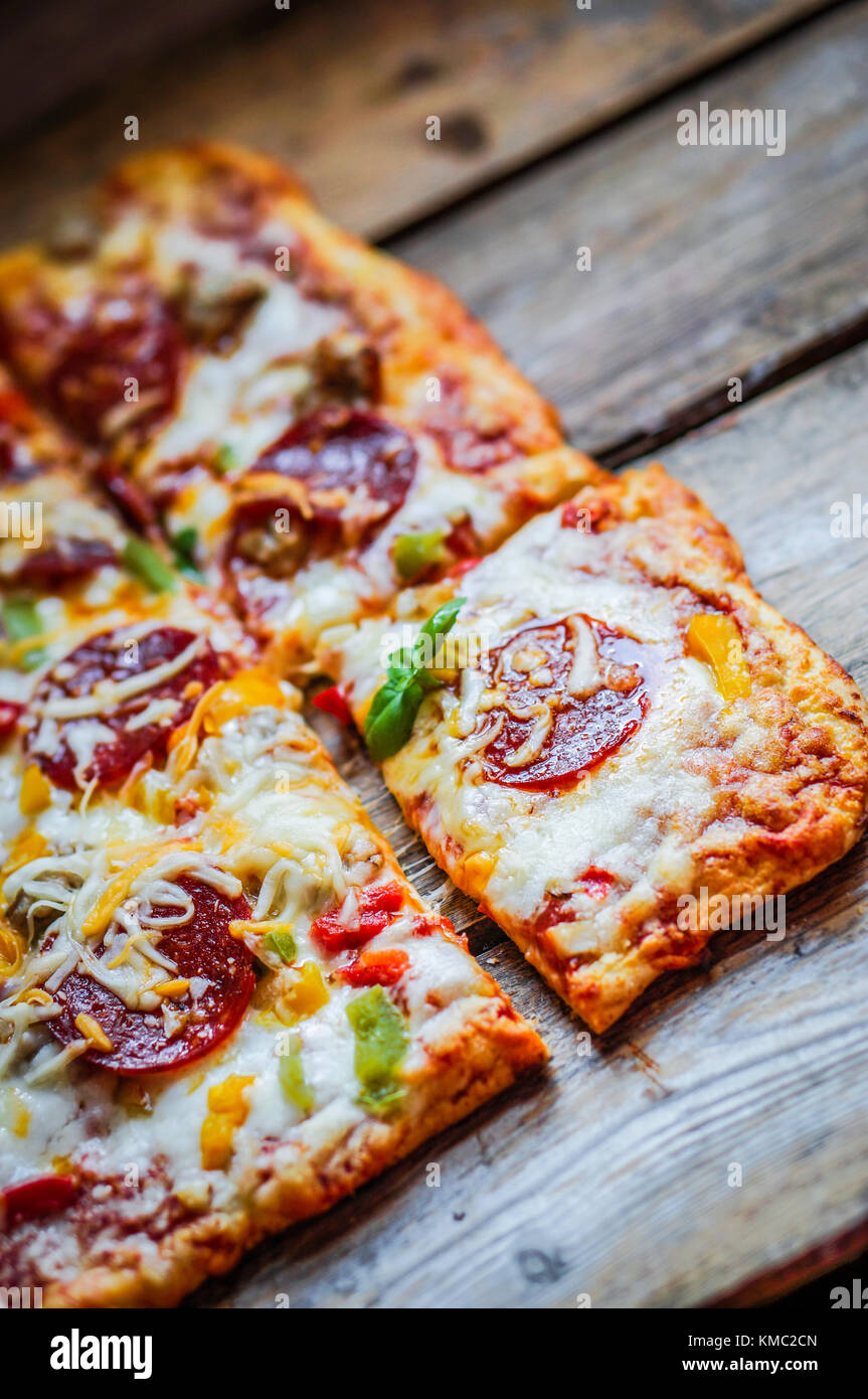 Square Pepperoni Pizza On Rustic Wooden Background Stock Photo - Alamy