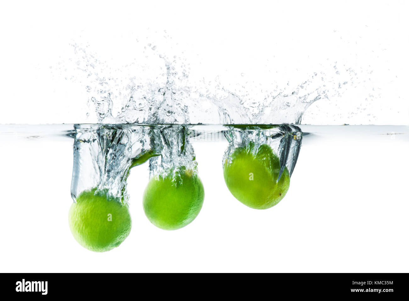 Fresh lime dropped into the water with water splash on a white ...