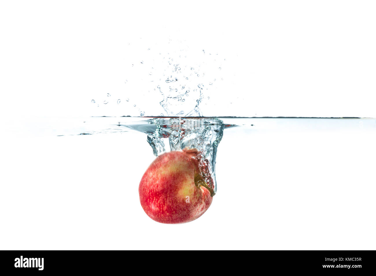 Red apple dropped into the water with water splash on a white ...