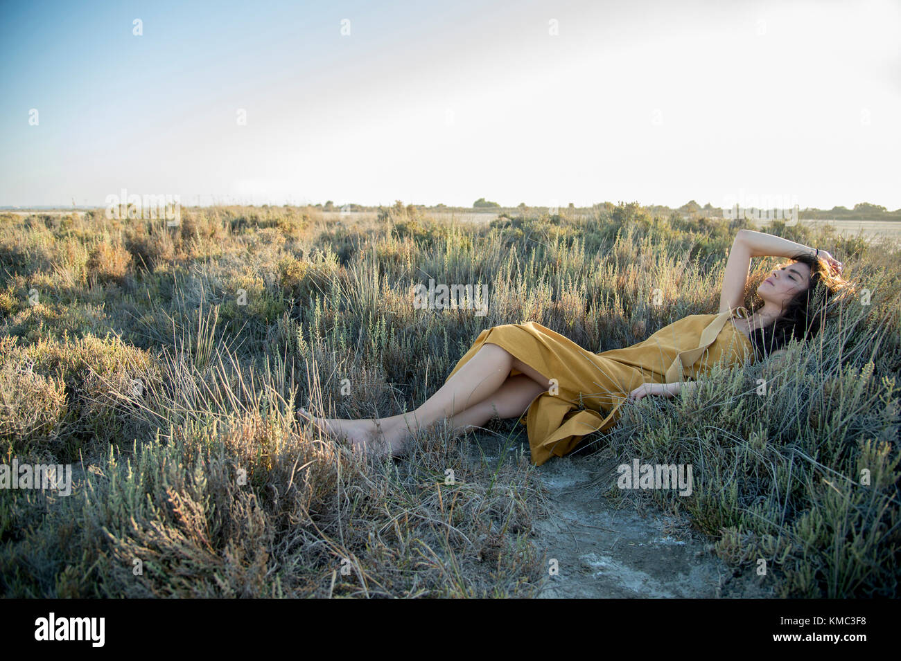 Young woman lying down, alone in nature Stock Photo - Alamy