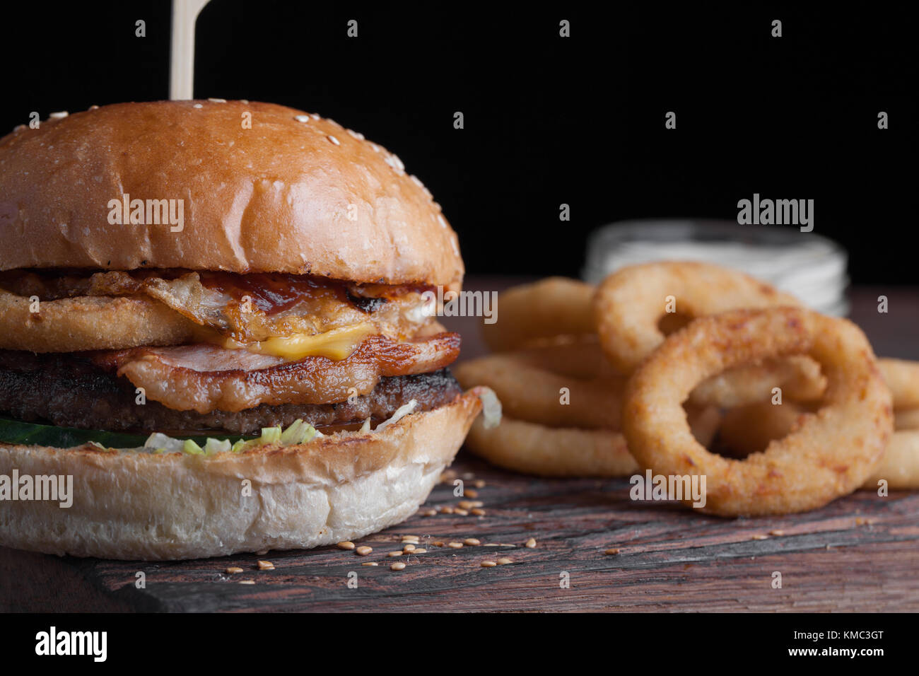 Closeup of a tasty Burger with appetizers such as fried onion rings ...