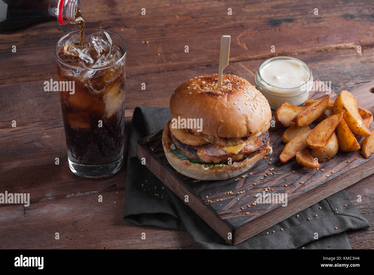 A tasty Burger with snacks in the form of potatoes with white garlic ...