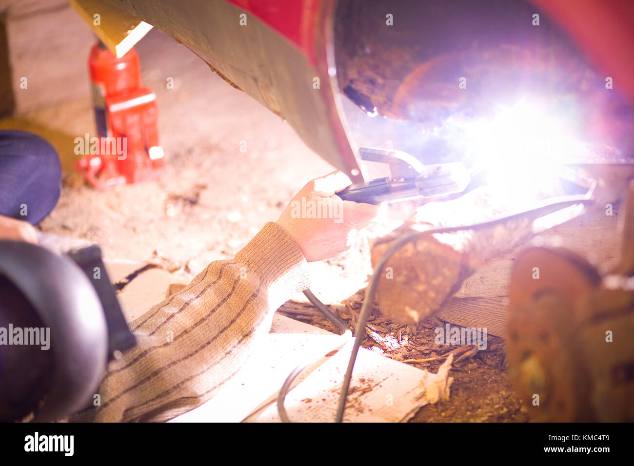 A man is fixing his rusty car with welding Stock Photo - Alamy