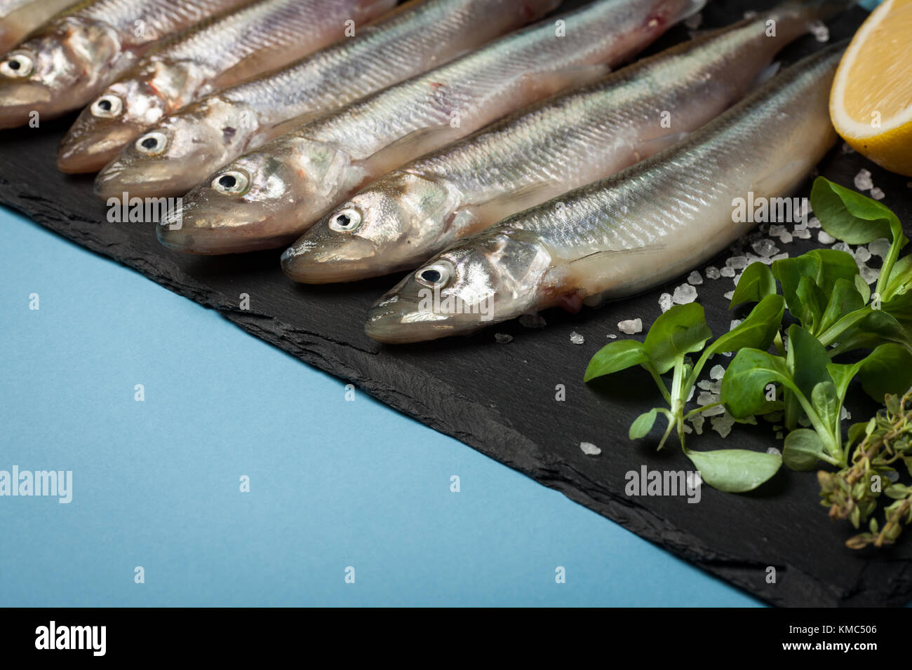 Fresh sea fish smelt or sardines ready for cooking with lemon, thyme ...