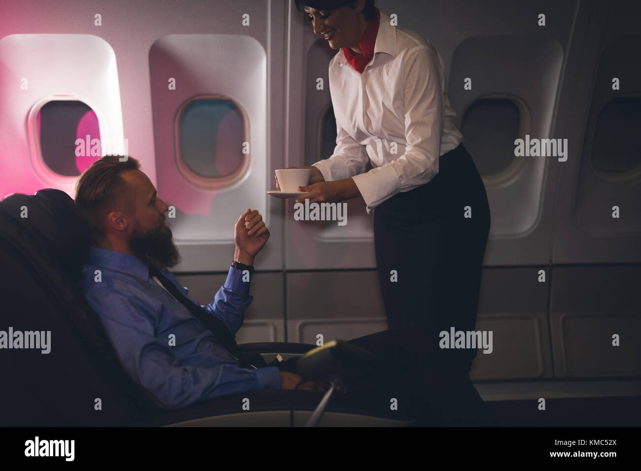 Air hostess serving coffee to businessman Stock Photo - Alamy