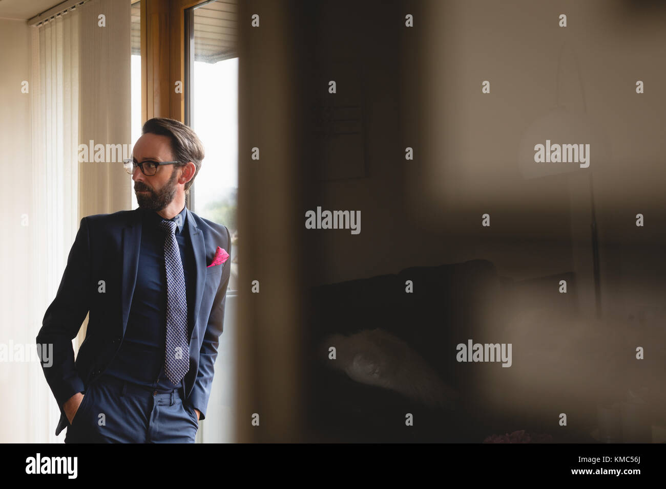 Man in full suit leaning on glass Stock Photo - Alamy