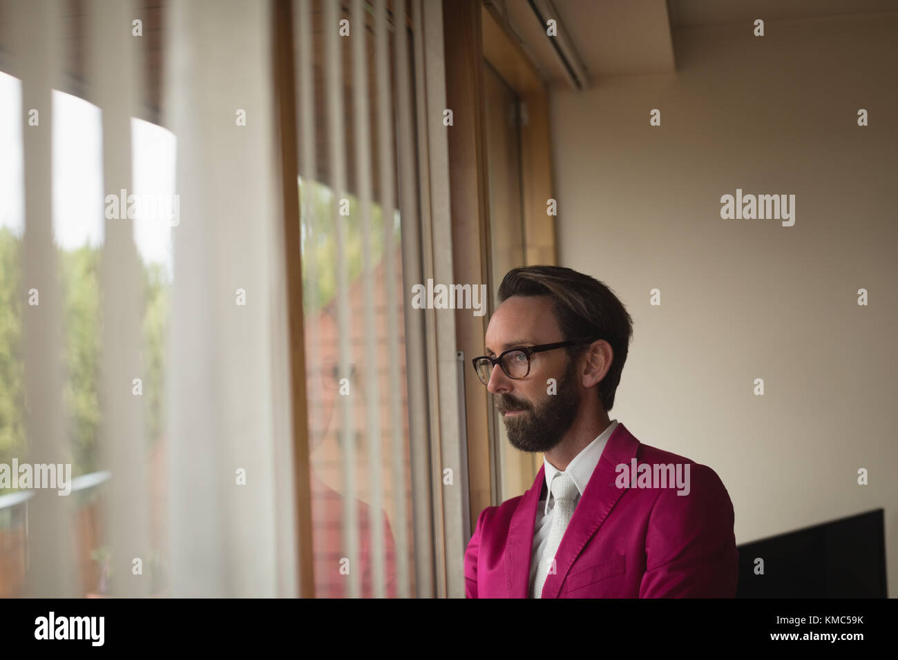 Man in suited looking through window Stock Photo - Alamy