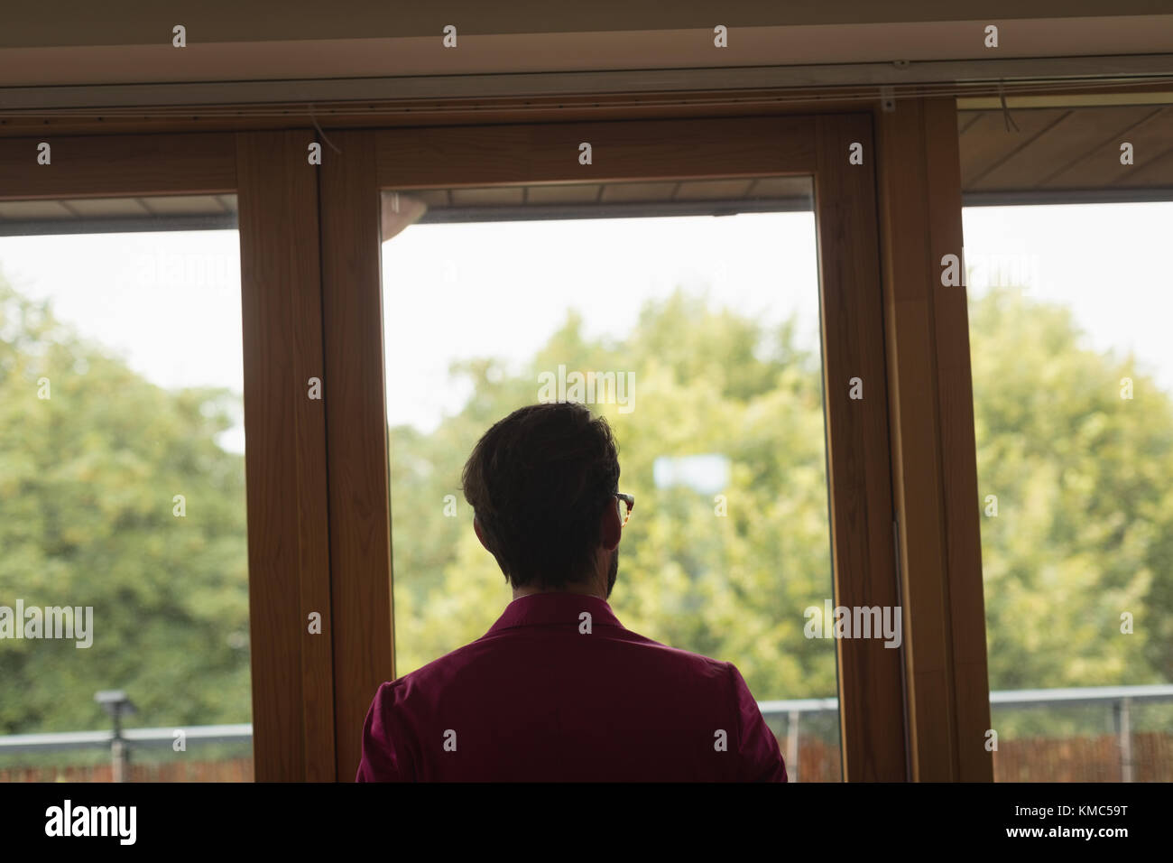 Man in suited looking through window Stock Photo - Alamy