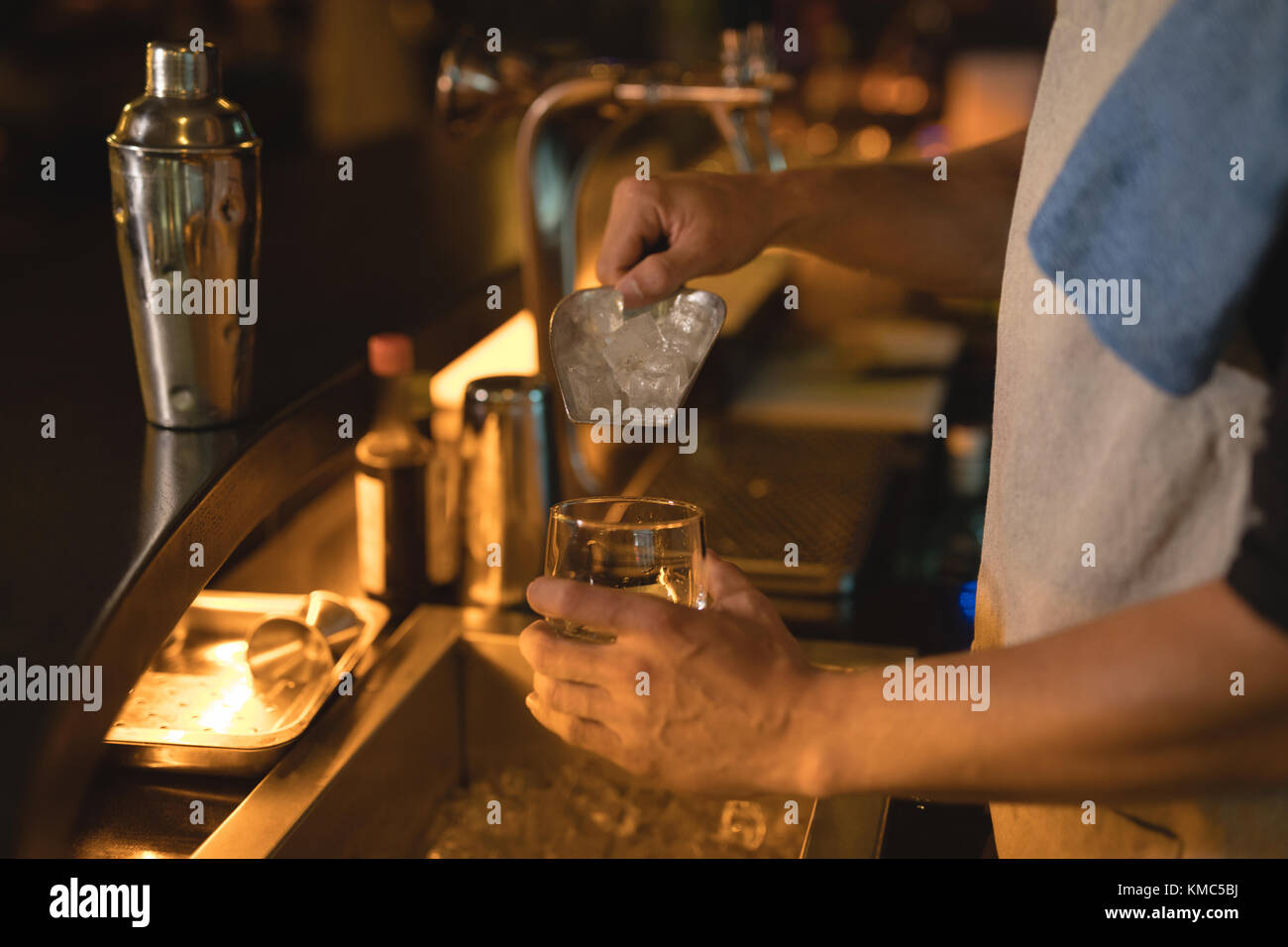 Waiter putting ice cubes into glass Stock Photo - Alamy