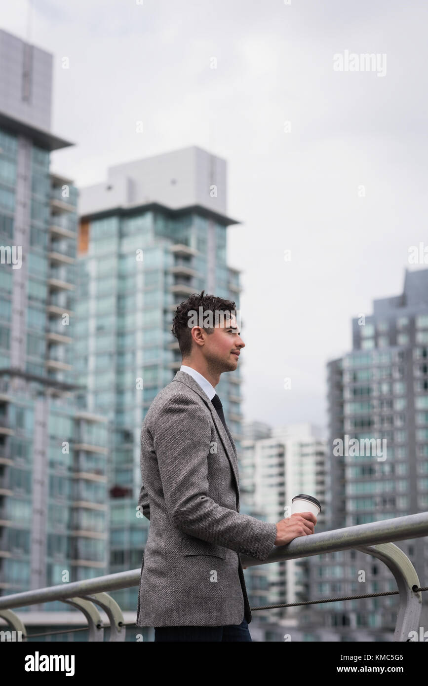 Businessman standing near railing Stock Photo - Alamy