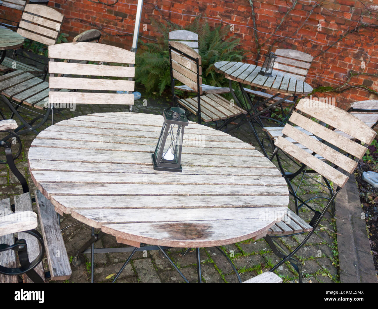 empty wooden public bench table and chairs with black lantern light box ...