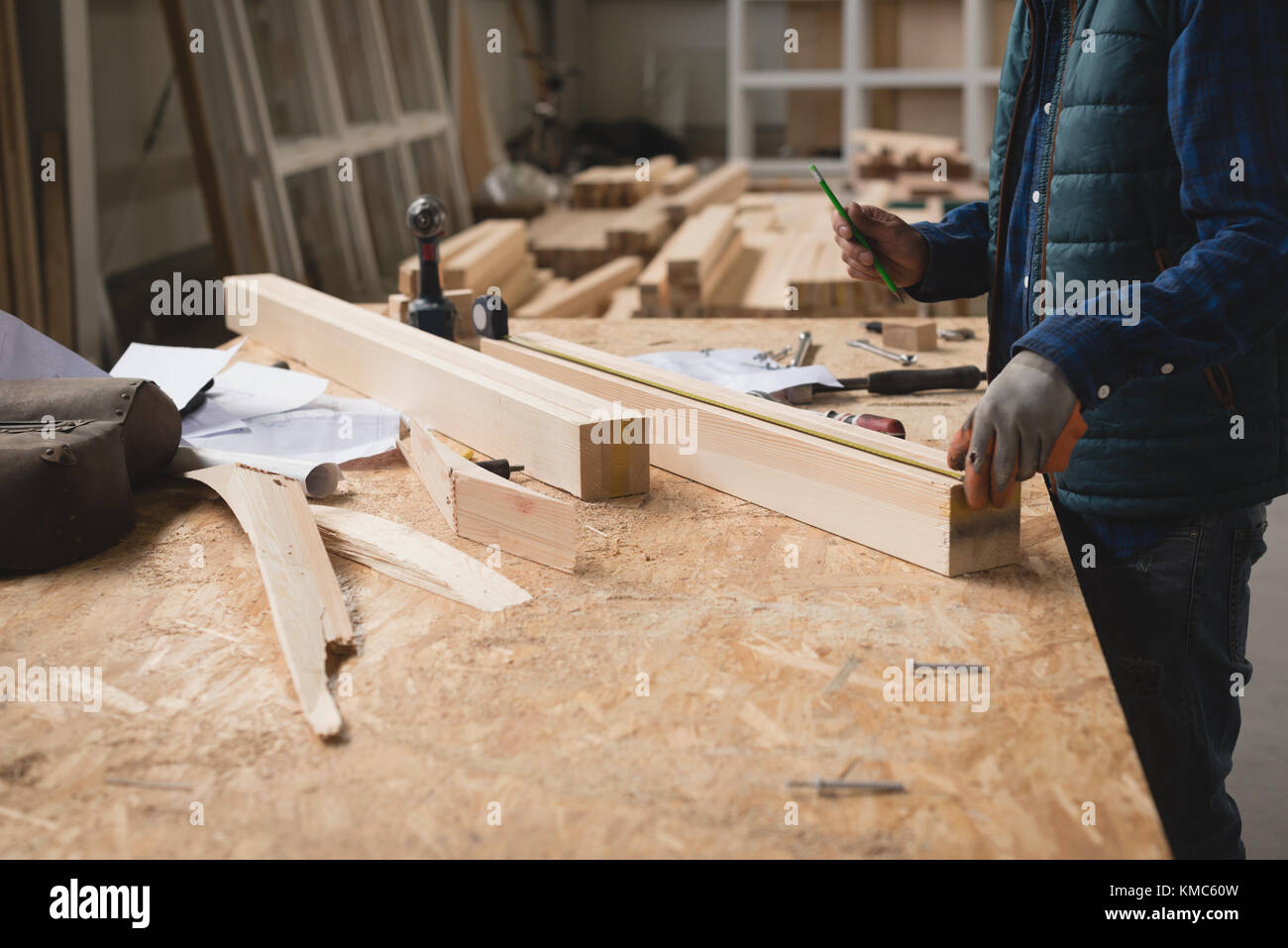Carpenter measuring wooden slab with measuring tape Stock Photo - Alamy