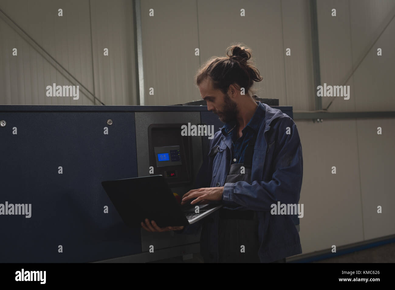 Mechanic using laptop near machine Stock Photo - Alamy