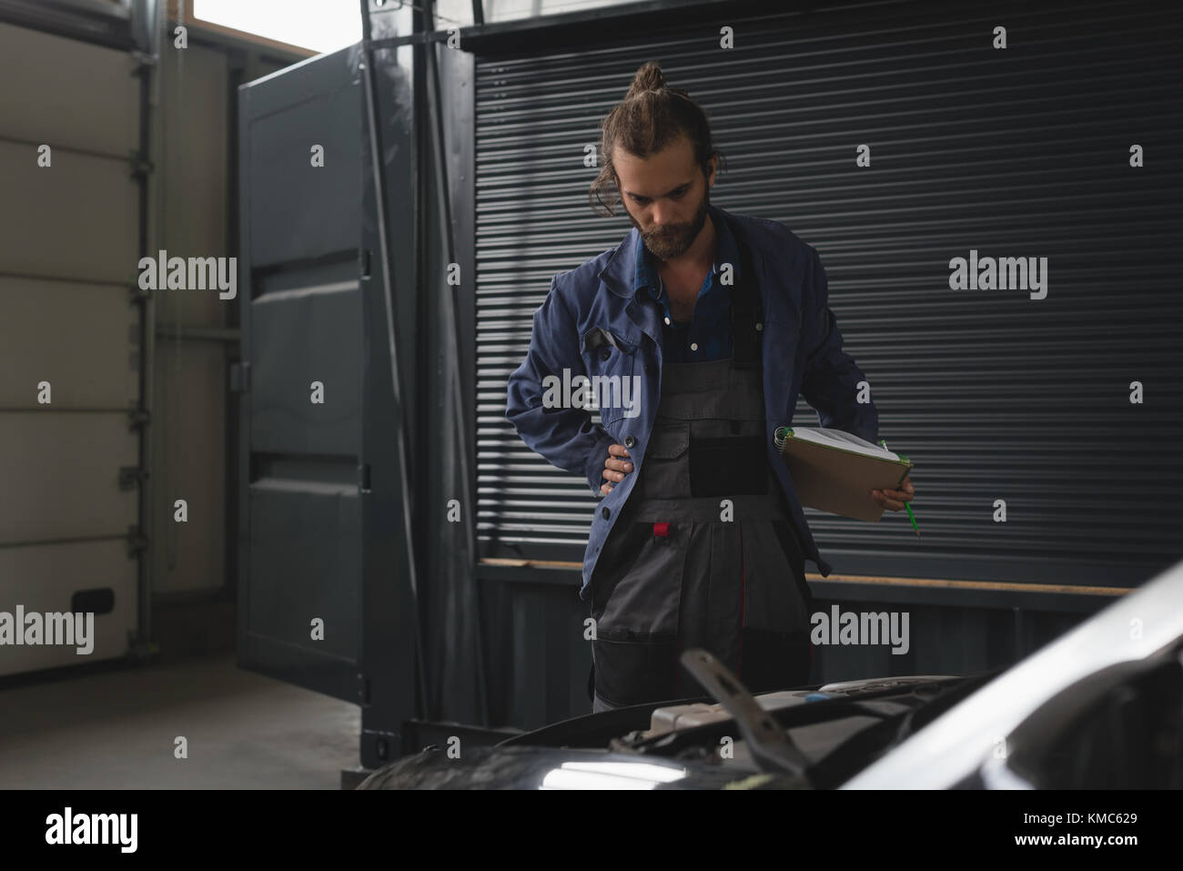 Mechanic looking at car Stock Photo - Alamy